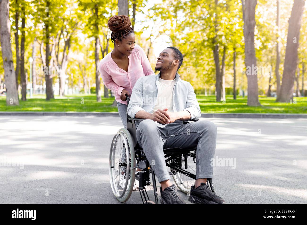 Affectionate black woman and her disabled boyfriend in wheelchair ...