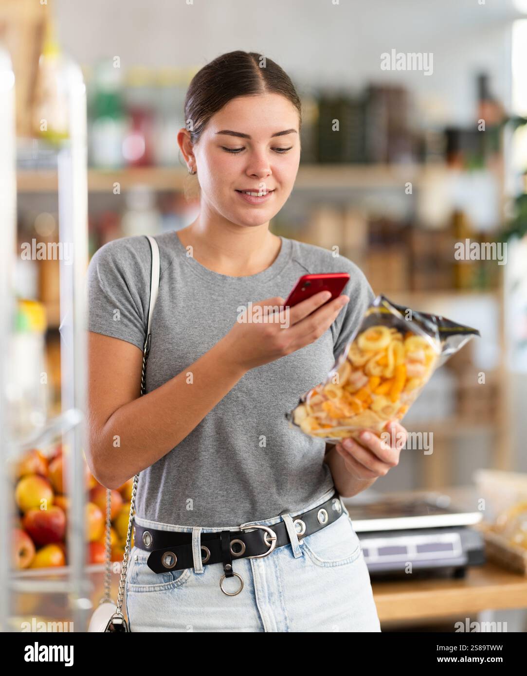 In shop youth girl scan QR code and take reading potato mix crisps ...