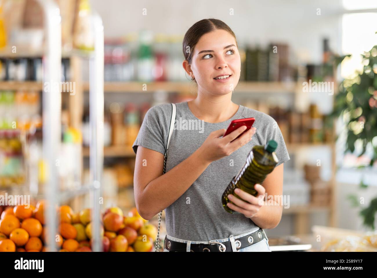 In shop youth girl scan QR code and take reading olive oil package ...