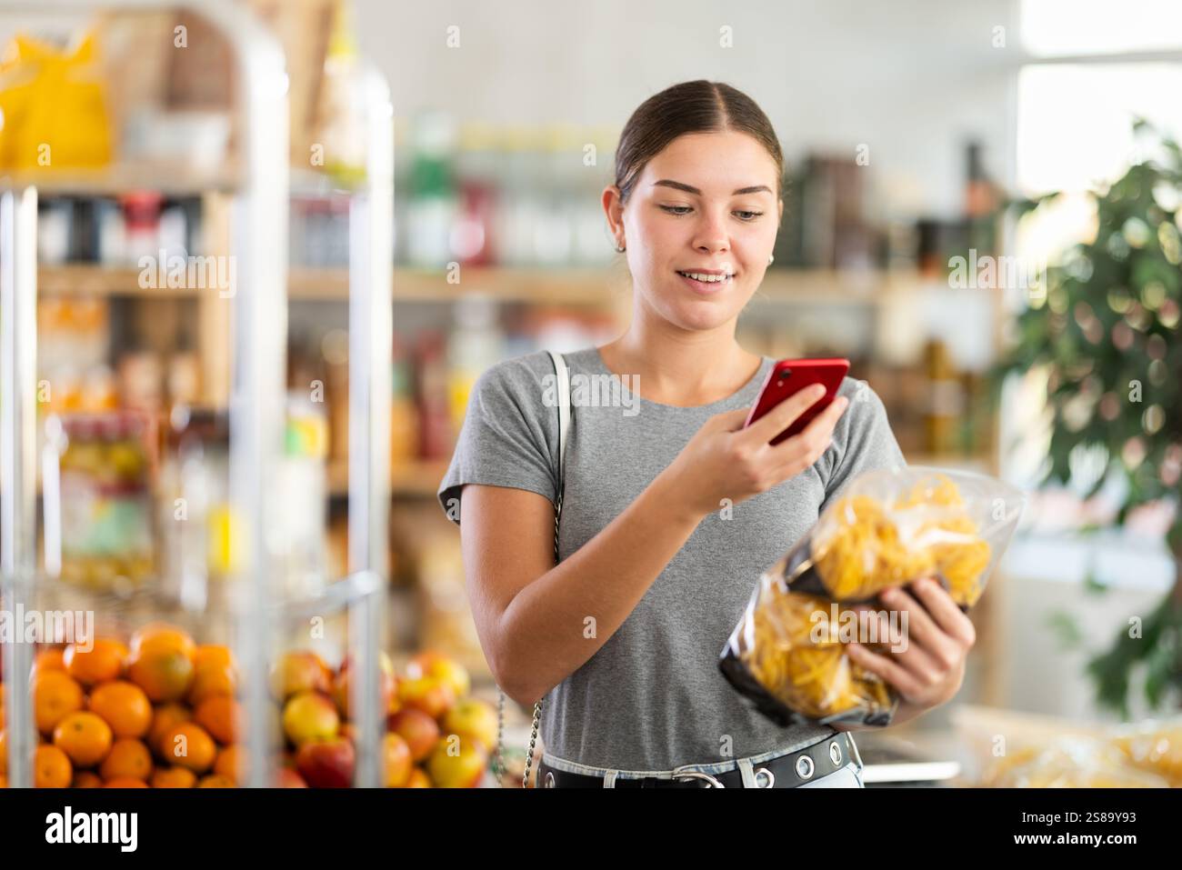 In shop European youth girl scan QR code and take reading pasta package ...