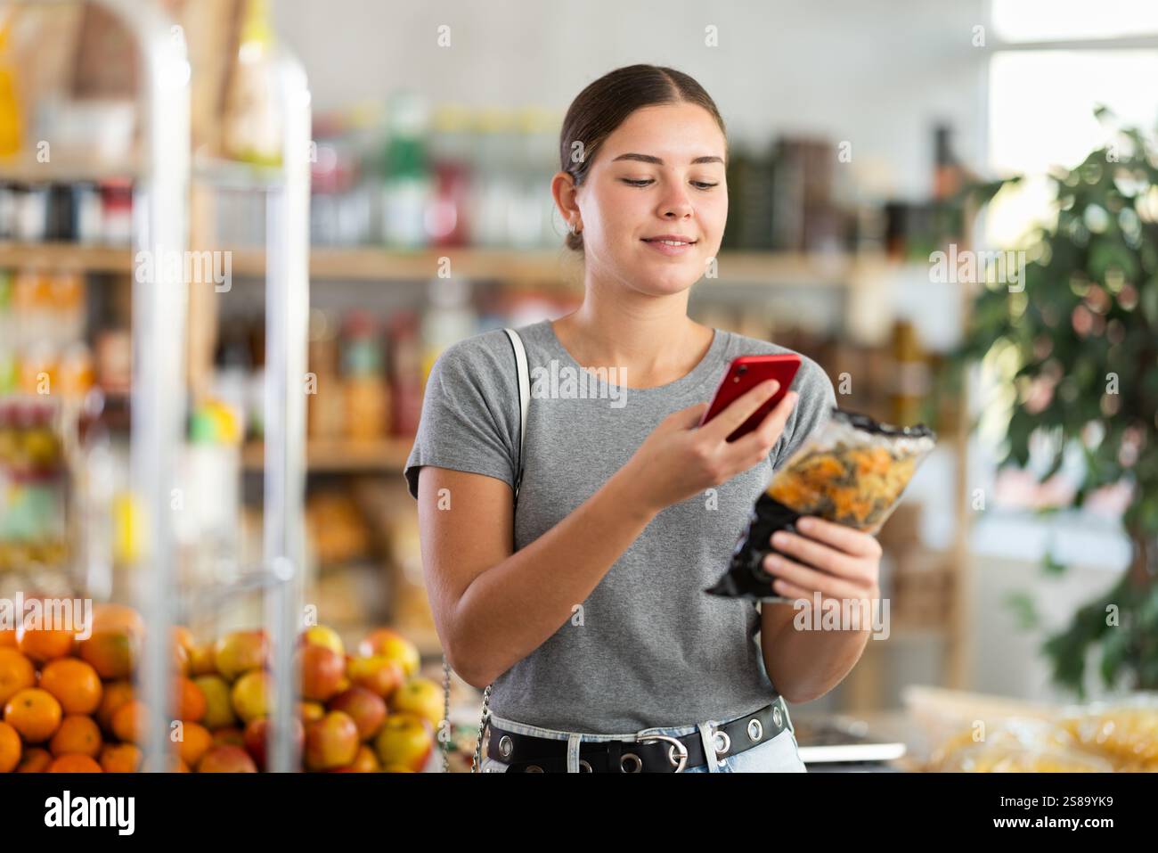 In shop European youth girl scan QR code and take reading pasta package ...