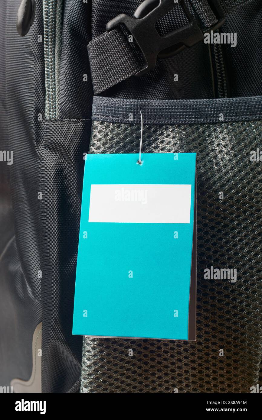 close-up of blank rectangular tag hanging from side pocket of backpack ...