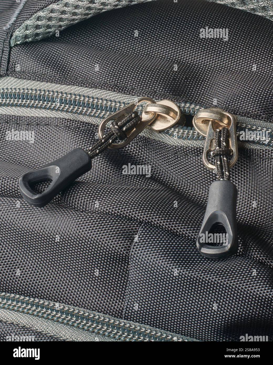 close-up of two zippers of main compartment of black backpack, pulls ...