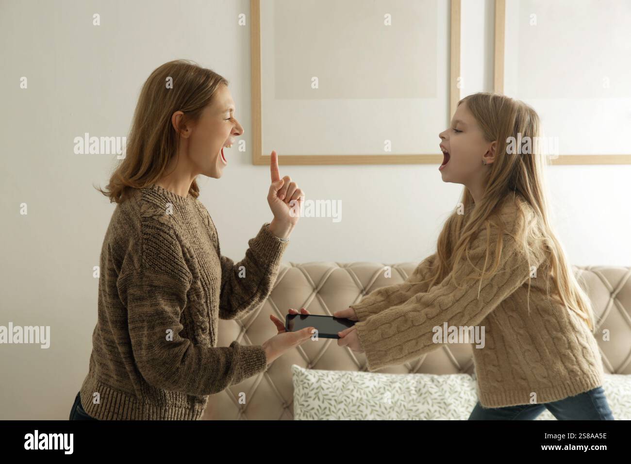 Angry mother shouting and arguing with her little daughter over over ...