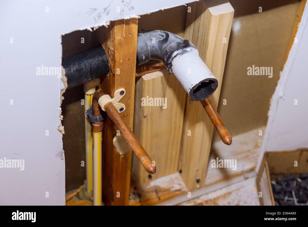 Renovation exposes plumbing pipes connections inside wall, revealing ...