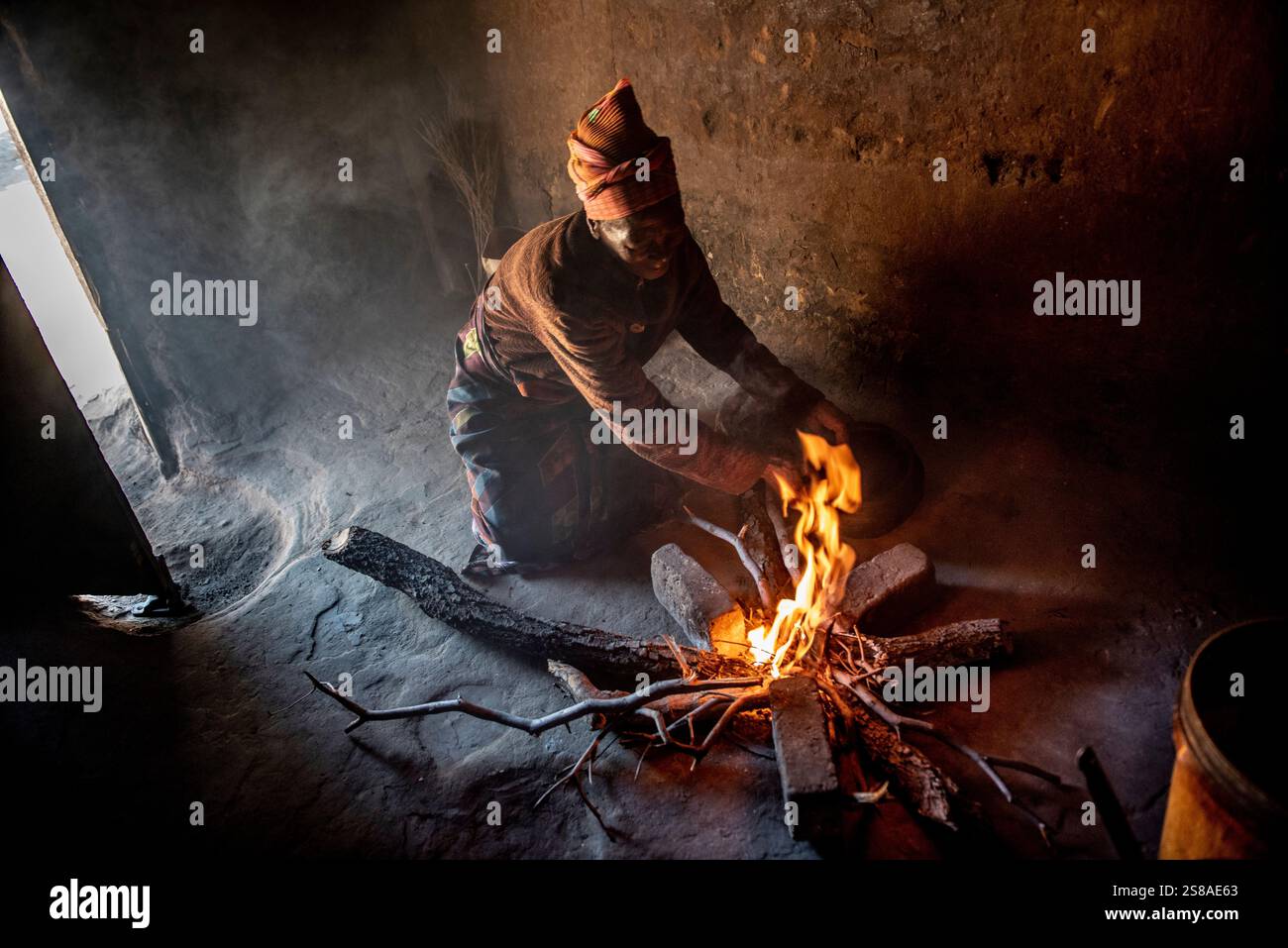Editorial use only Woman building a fire indoors. Photographed in Besa ...
