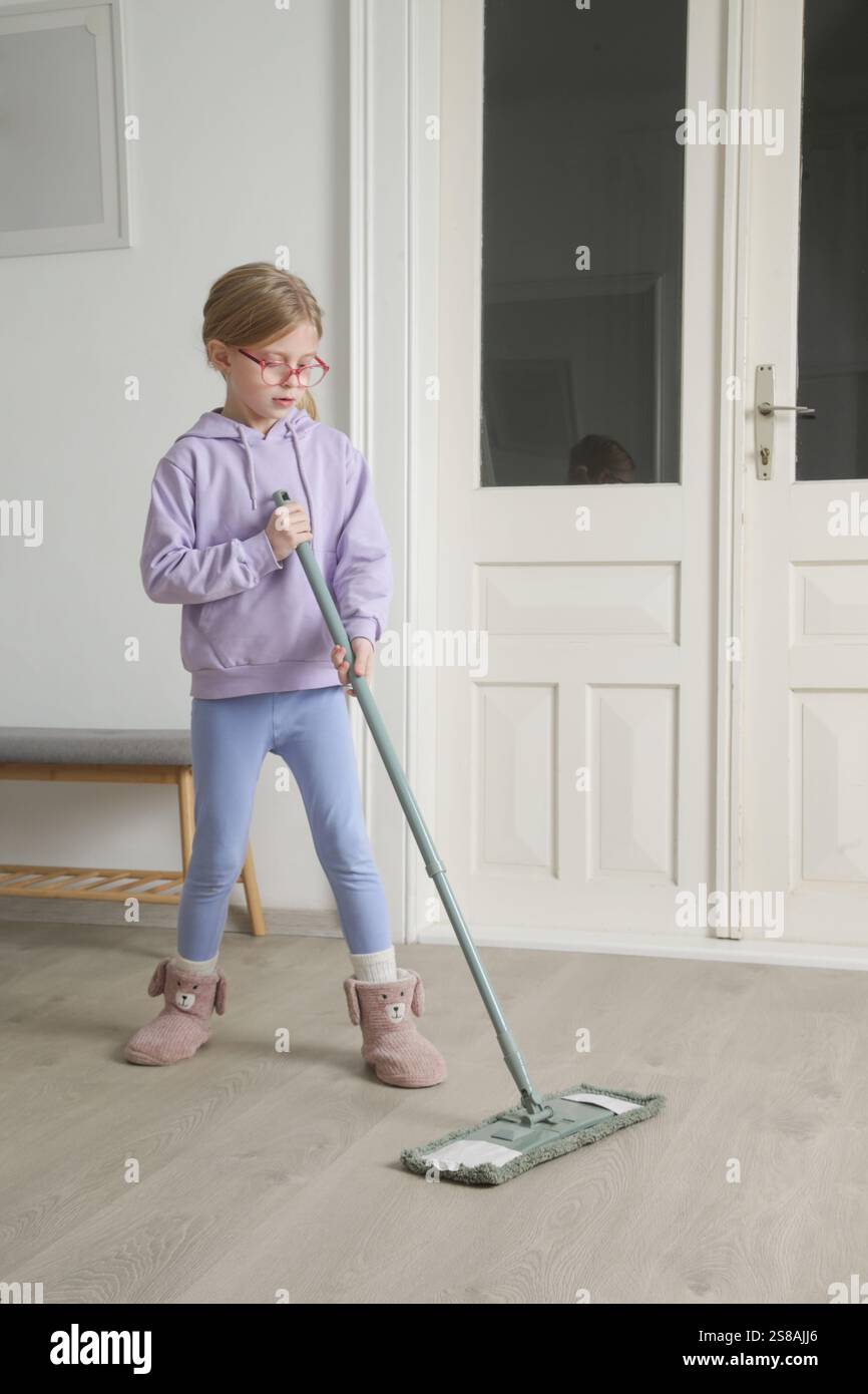 Cute little girl mopping floor Stock Photo - Alamy