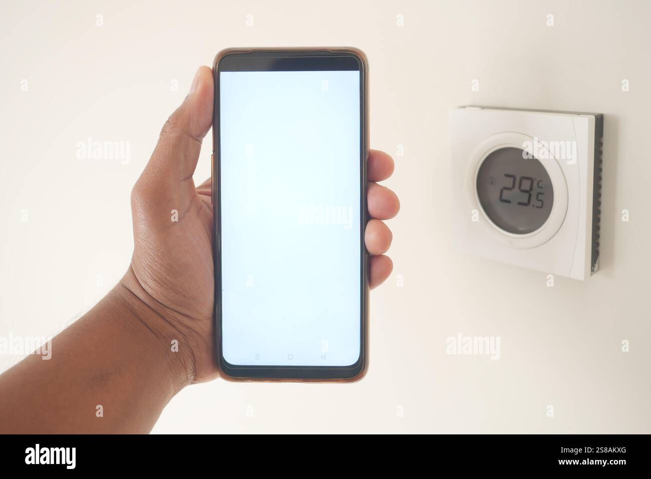 Hand Utilizing Smartphone to Interact with Digital Thermostat for ...