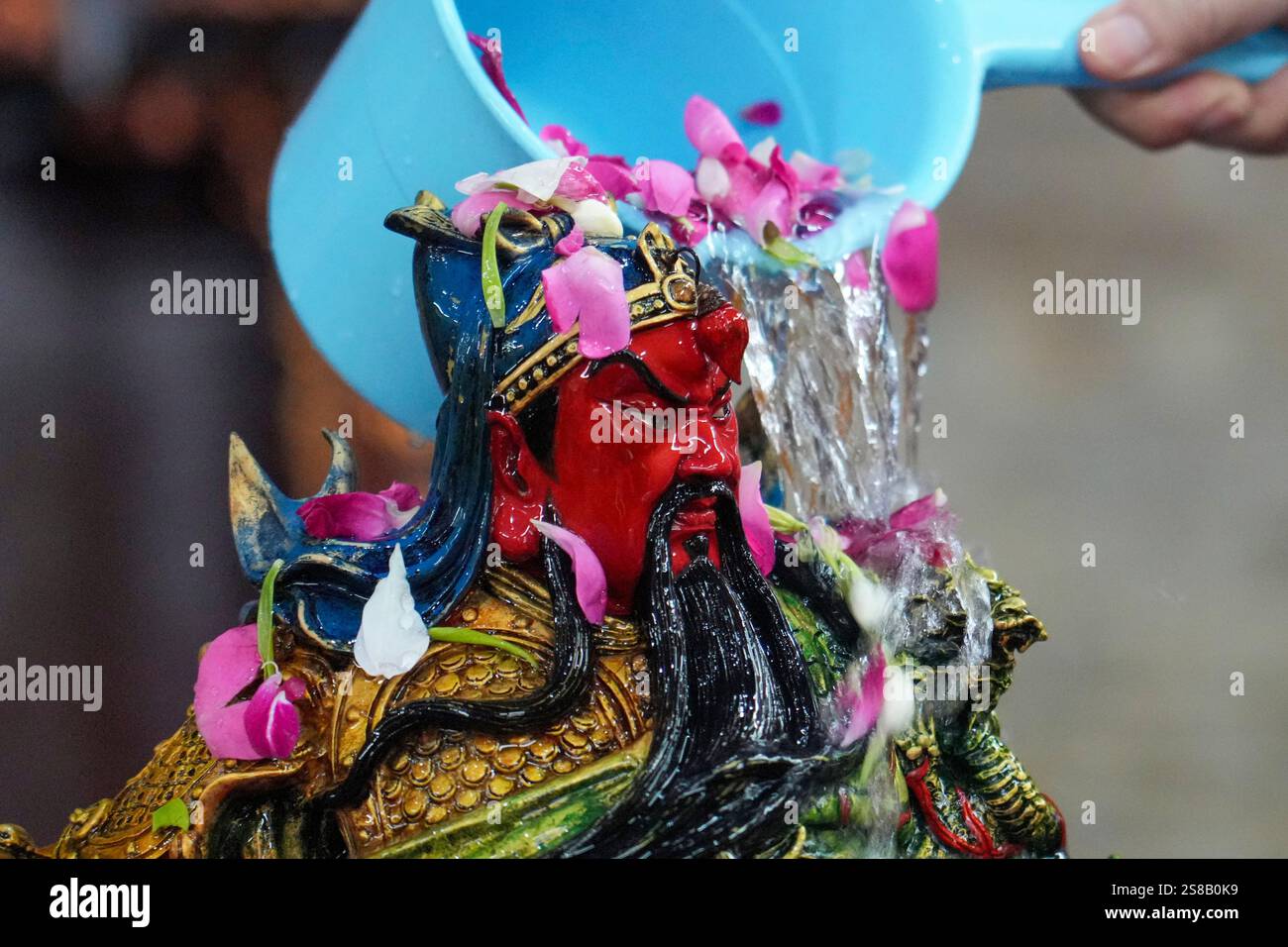 A Chinese god statue is cleaned in preparation for the Lunar New Year ...