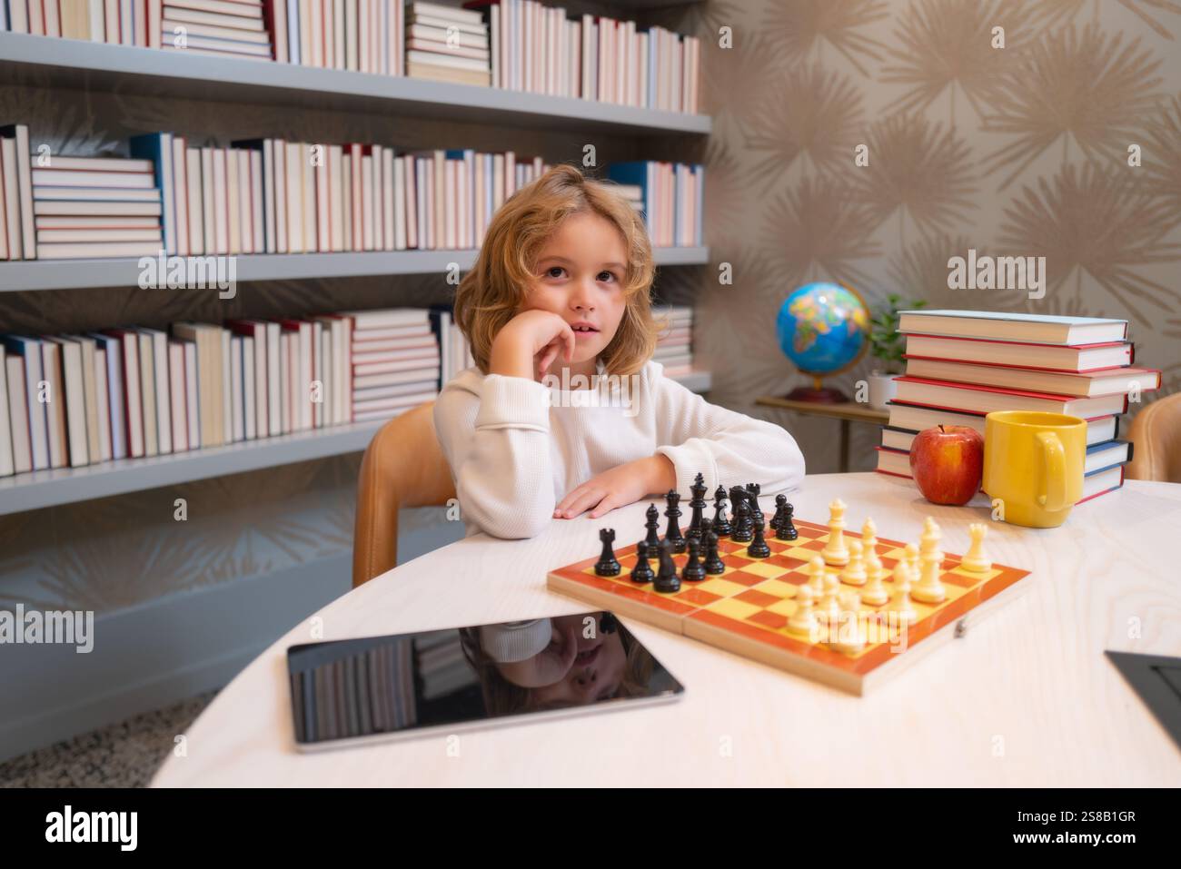 Chess game for kids. Child playing chess at home Stock Photo - Alamy