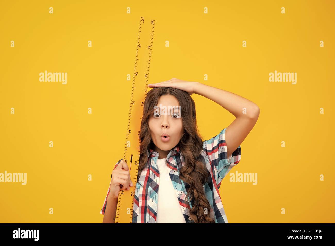 Funny face. Teenager child school girl holding measure for geometry ...