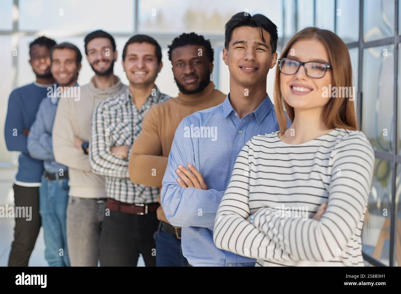 Portrait of multicultural office staff standing in the lobby in a row ...