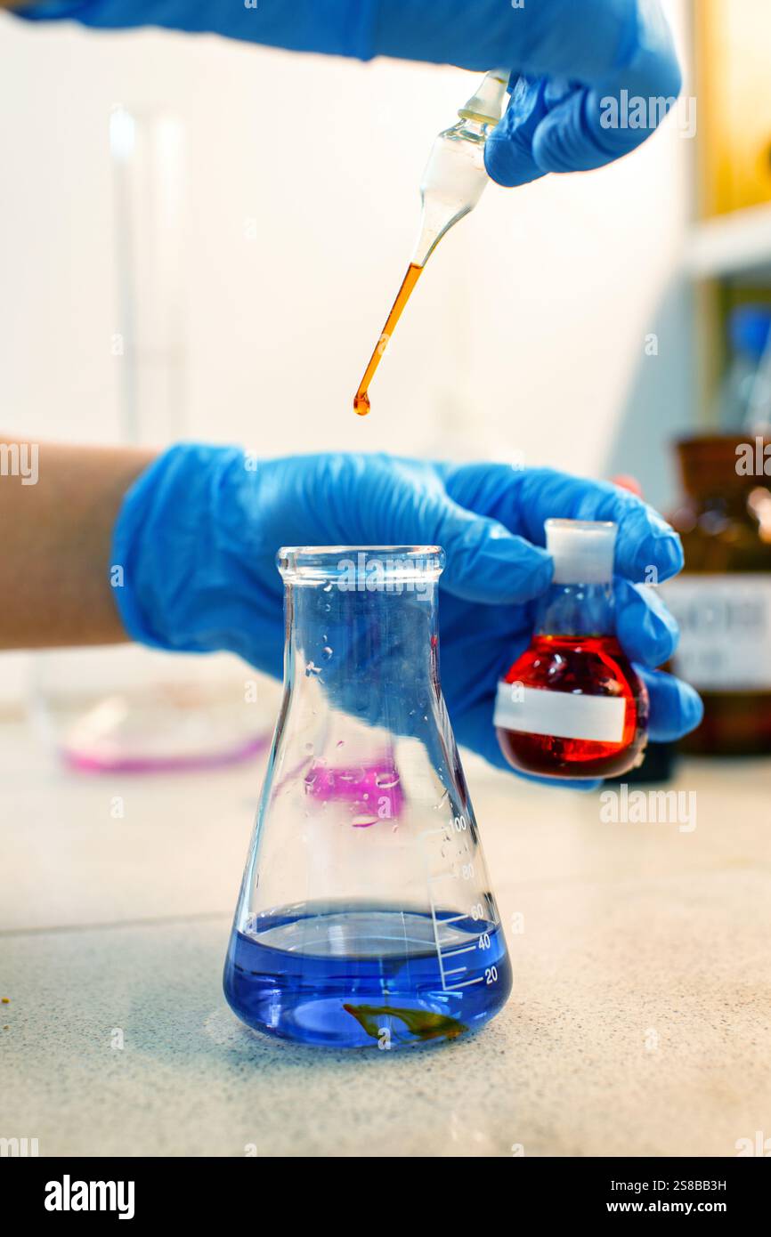 Chemistry experiment involves mixing colored liquids in laboratory ...