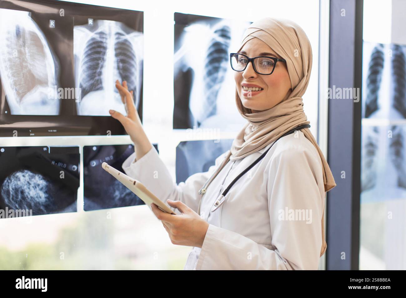 Confident Muslim woman doctor studies x-rays, showcasing expertise in radiology. Young ...