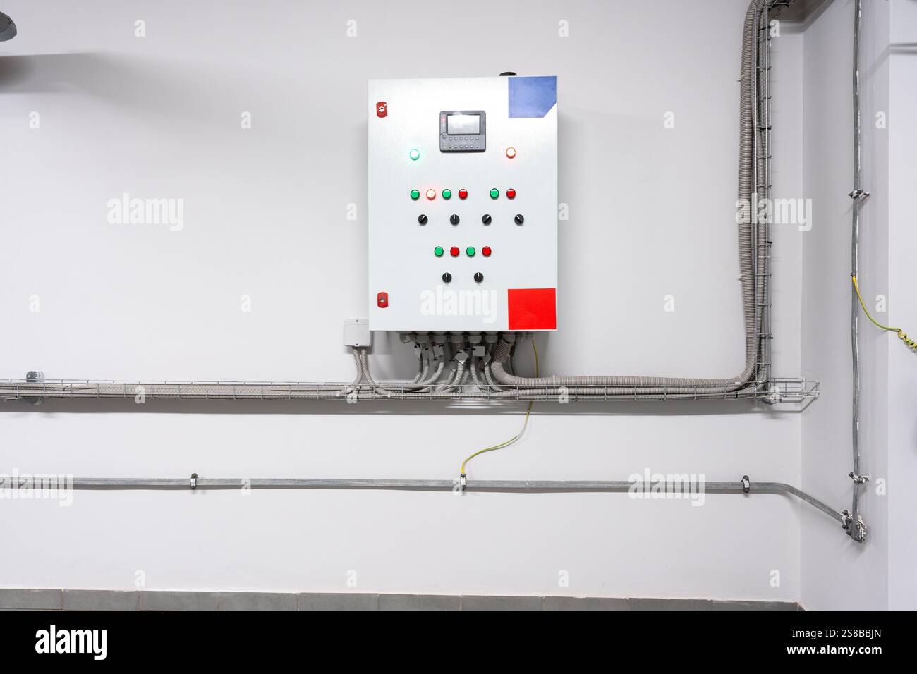 Control panel mounted on a wall with various indicator lights and ...