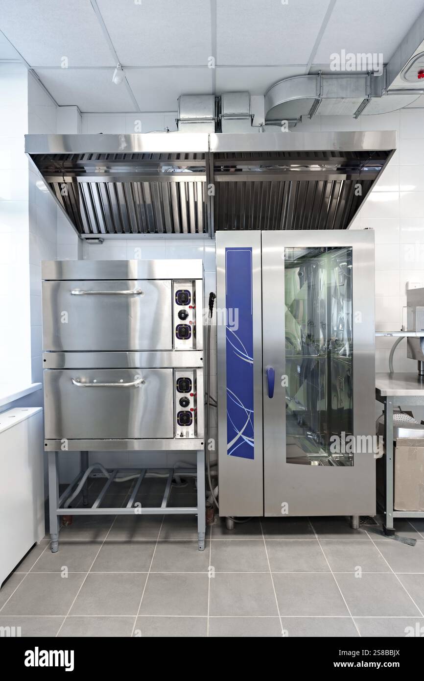 Stainless steel kitchen equipment setup with double oven and combi oven ...