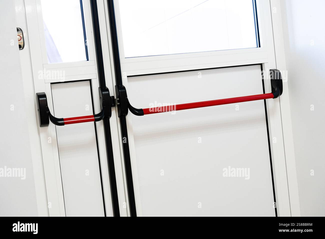 Red handle door assembly at a modern building entrance for easy ...