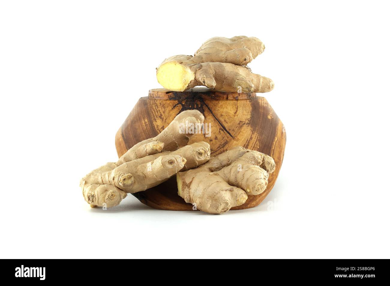 Collection of ginger roots arranged in rustic wooden bowl, capturing ...