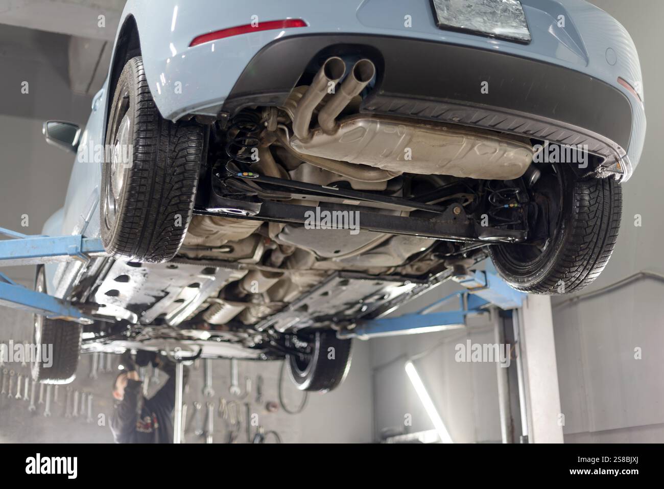 Modern car lifted on a hydraulic platform in an auto repair shop ...