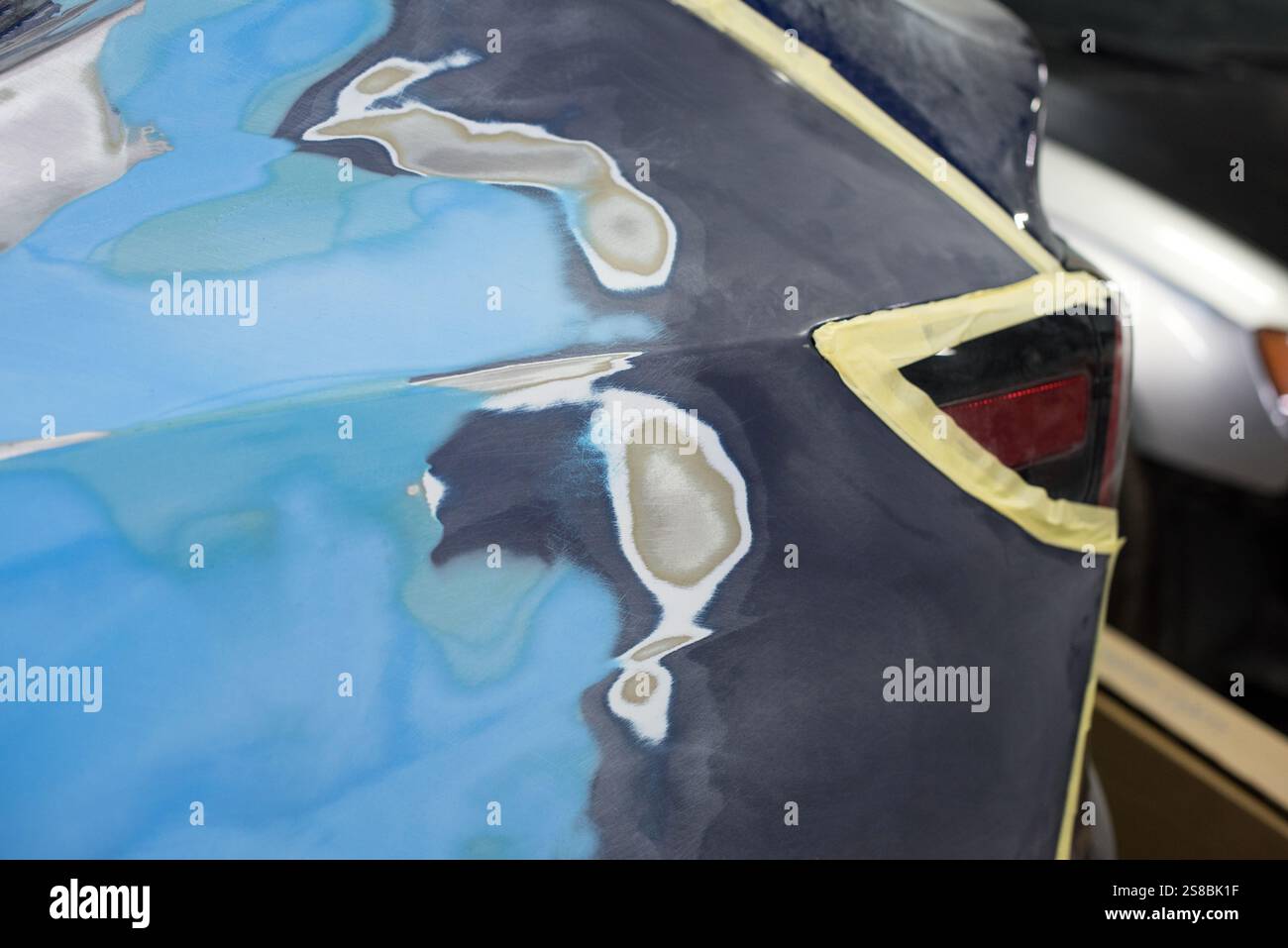Close-Up of Car Being Repaired Showing Masked and Painted Bodywork. The ...