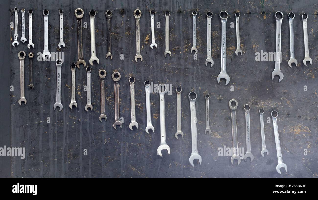 Hand tools neatly displayed on a vertical board in a workshop. An array ...