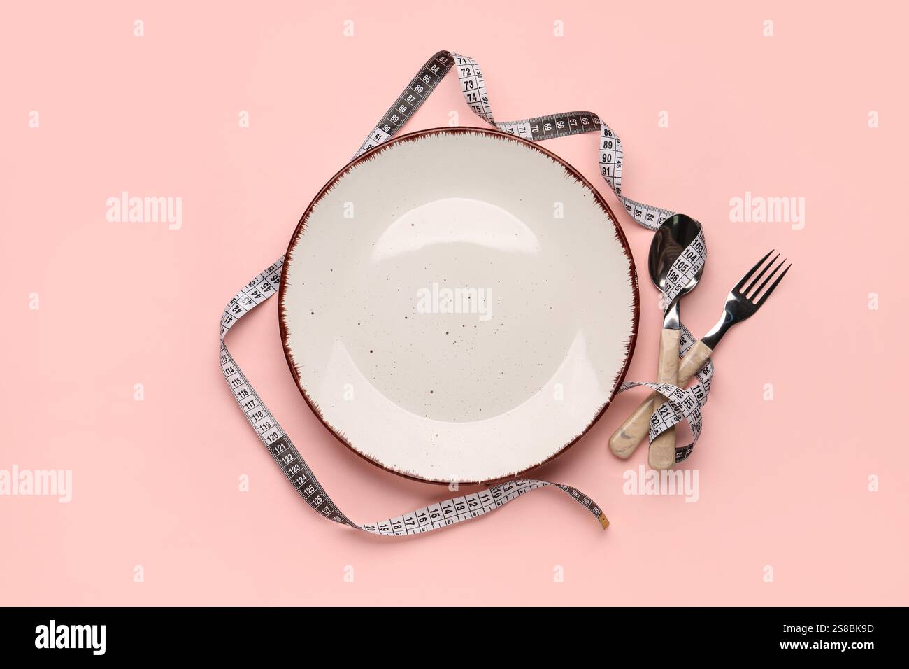 Table setting with measuring tape on pink background Stock Photo - Alamy