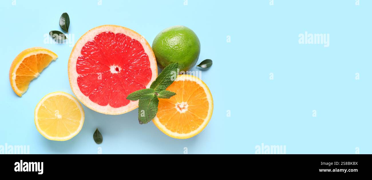 Many different citrus fruits on light blue background with space for ...