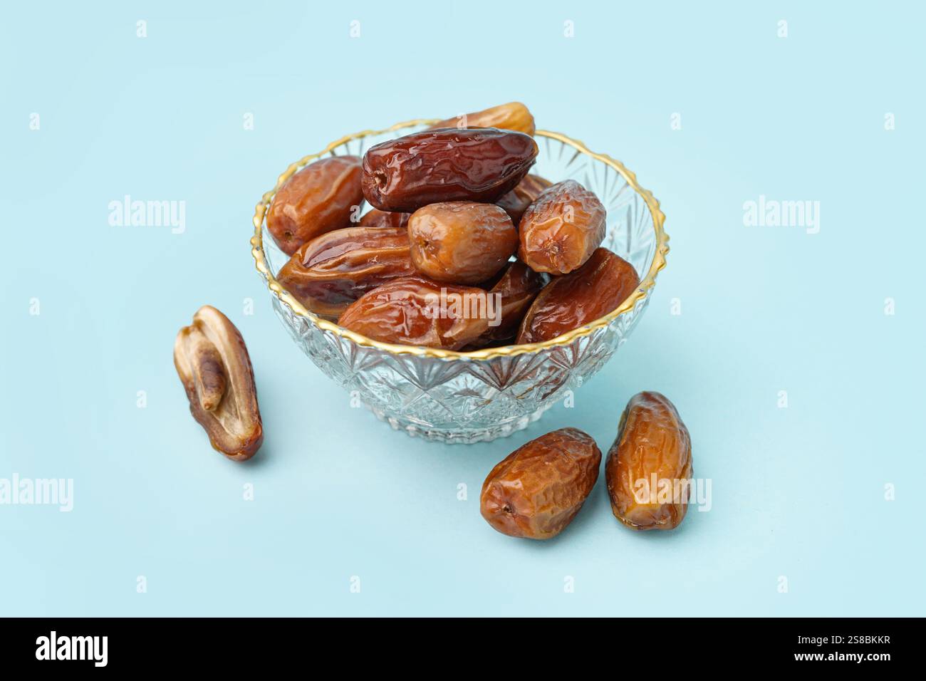 Bowl with dried dates on blue background Stock Photo - Alamy