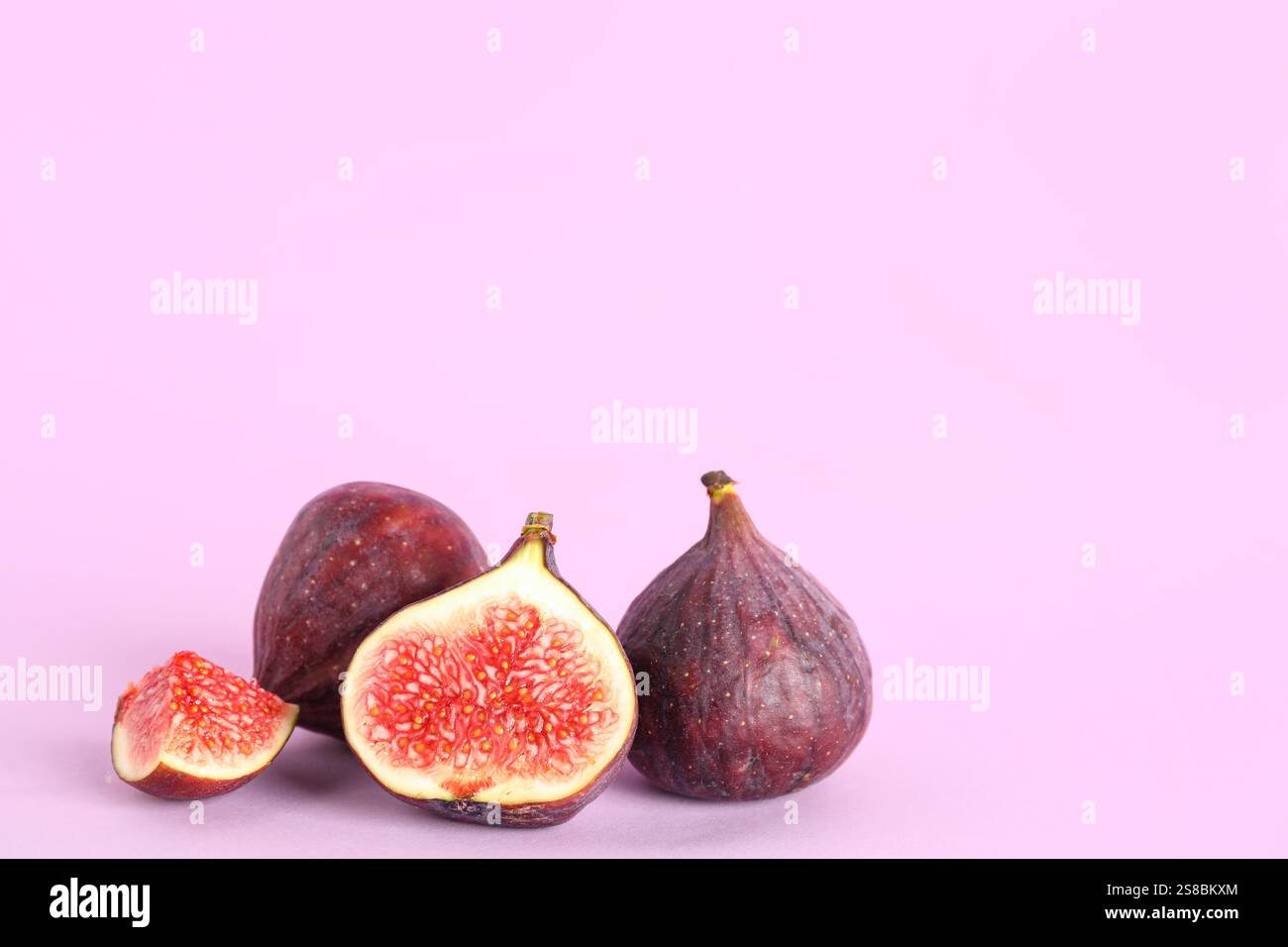 Fresh juicy cut figs on lilac background Stock Photo - Alamy