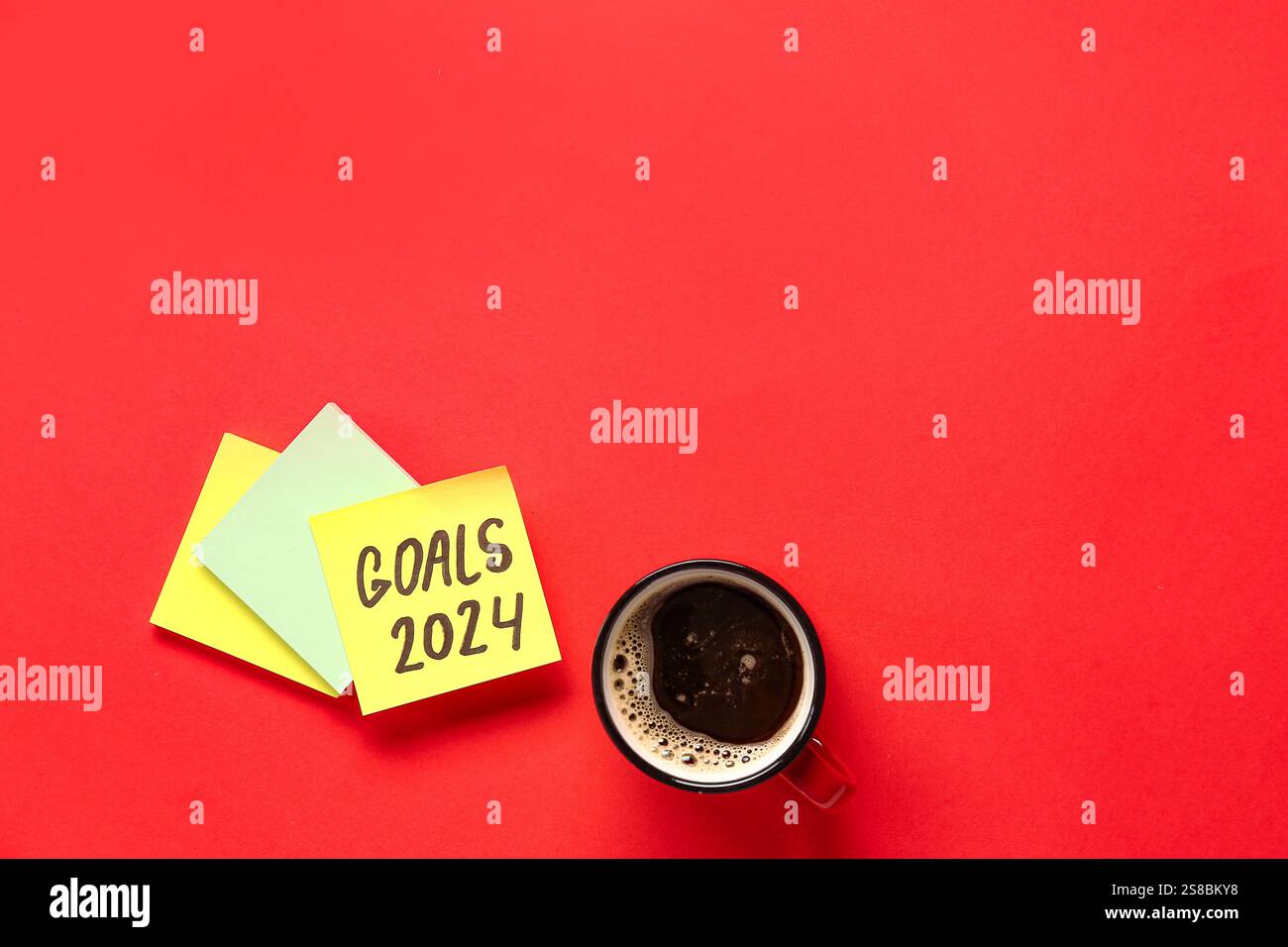 Sticky notes with goals for 2024 and cup of coffee on red background ...