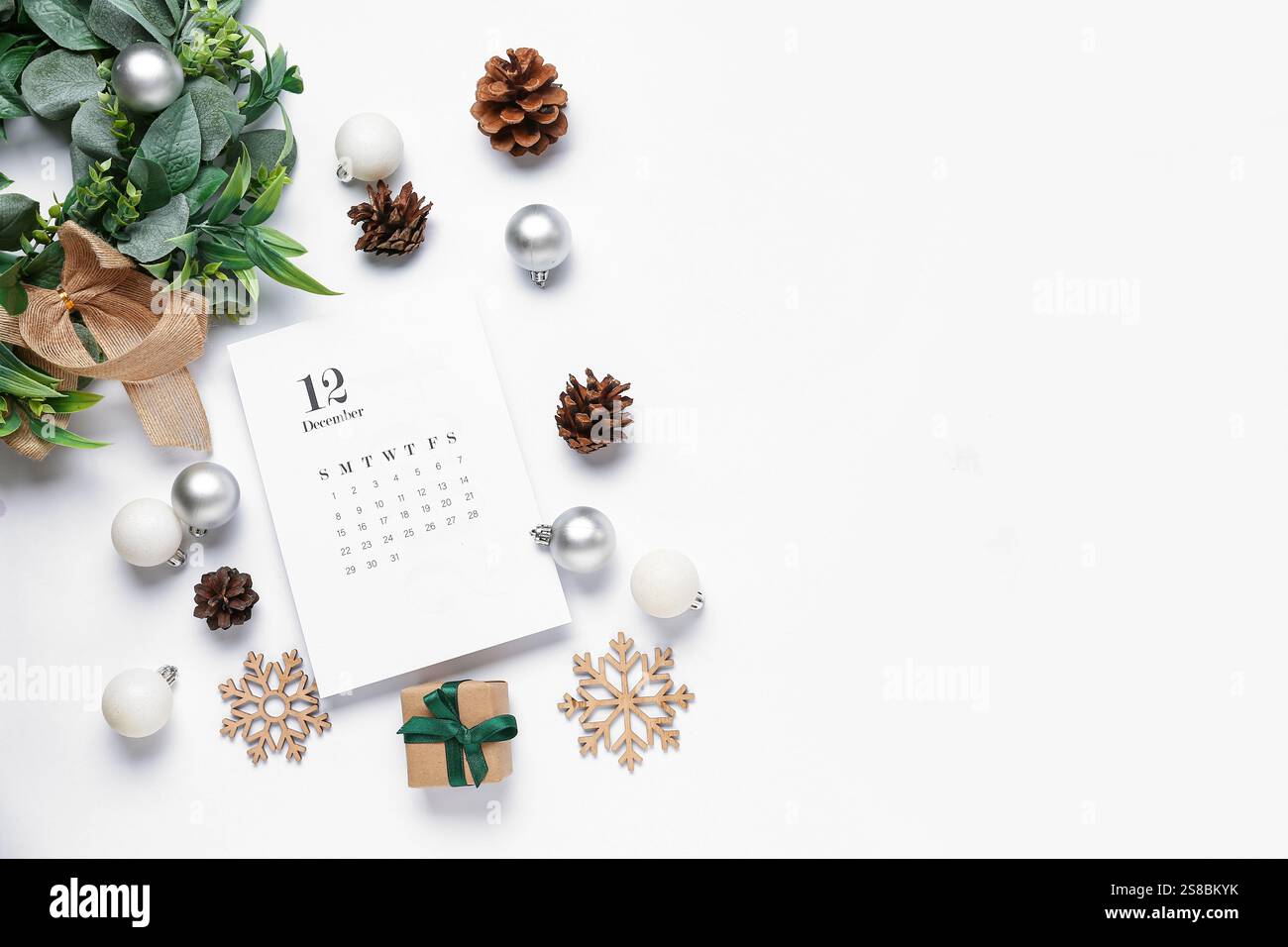 Paper calendar for December 12 with mistletoe wreath, gift box and ...