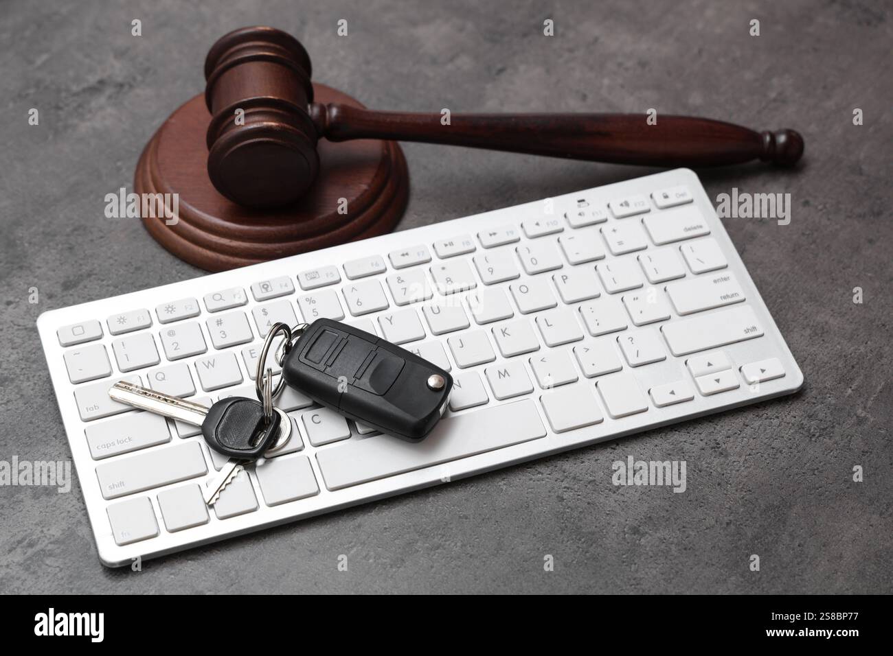 Car key with computer keyboard and auction gavel on dark background ...