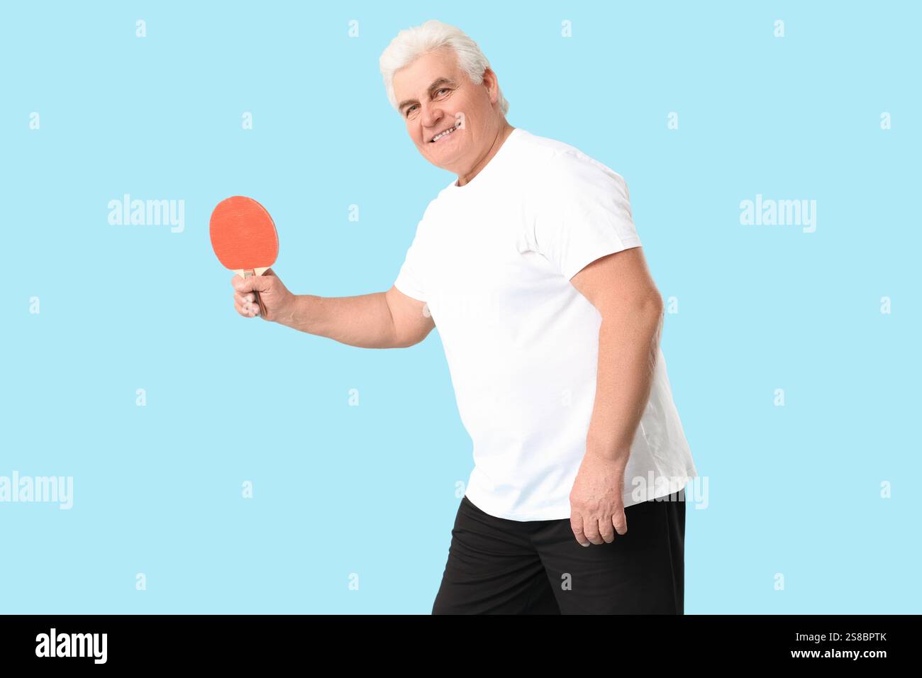 Sporty senior man with ping-pong racket on blue background Stock Photo ...