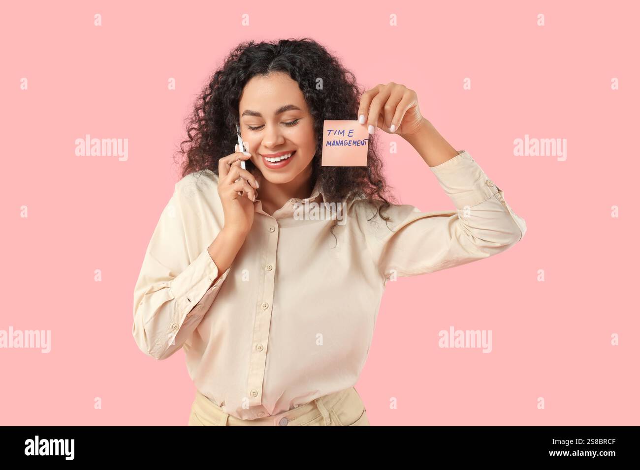 Young African-American woman holding paper with text TIME MANAGEMENT ...