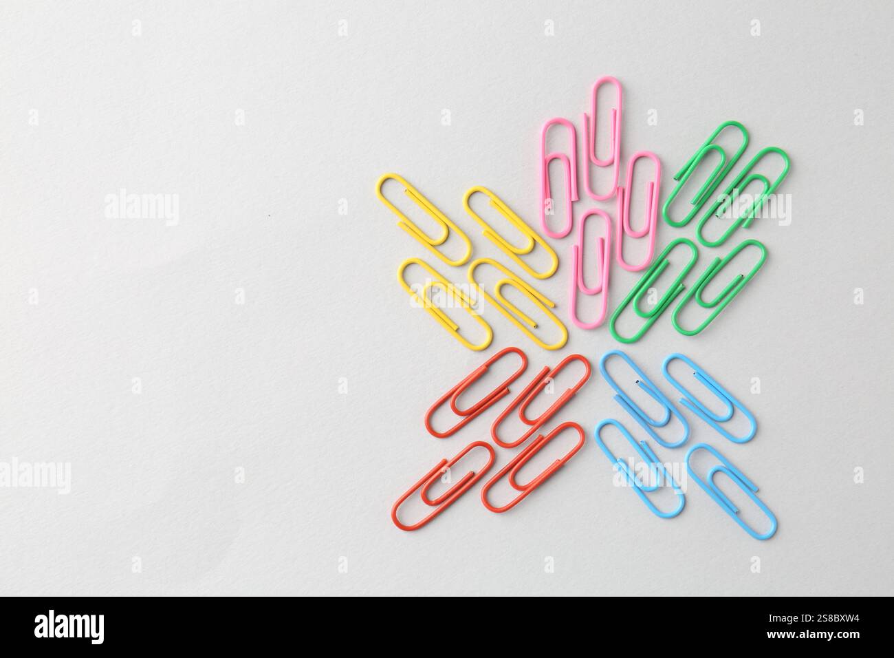 Colorful paper clips on light background, flat lay. Space for text ...