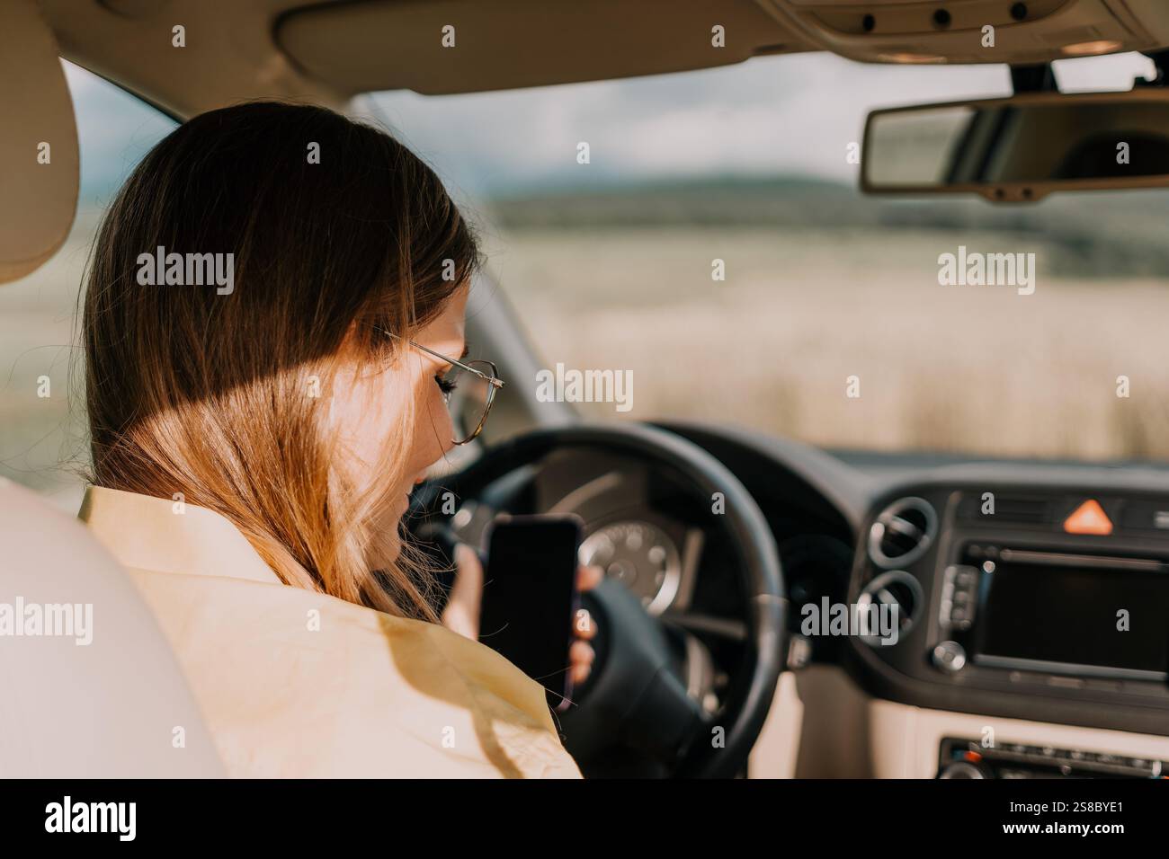 Woman Driving a Car and Looking at Her Phone Stock Photo - Alamy