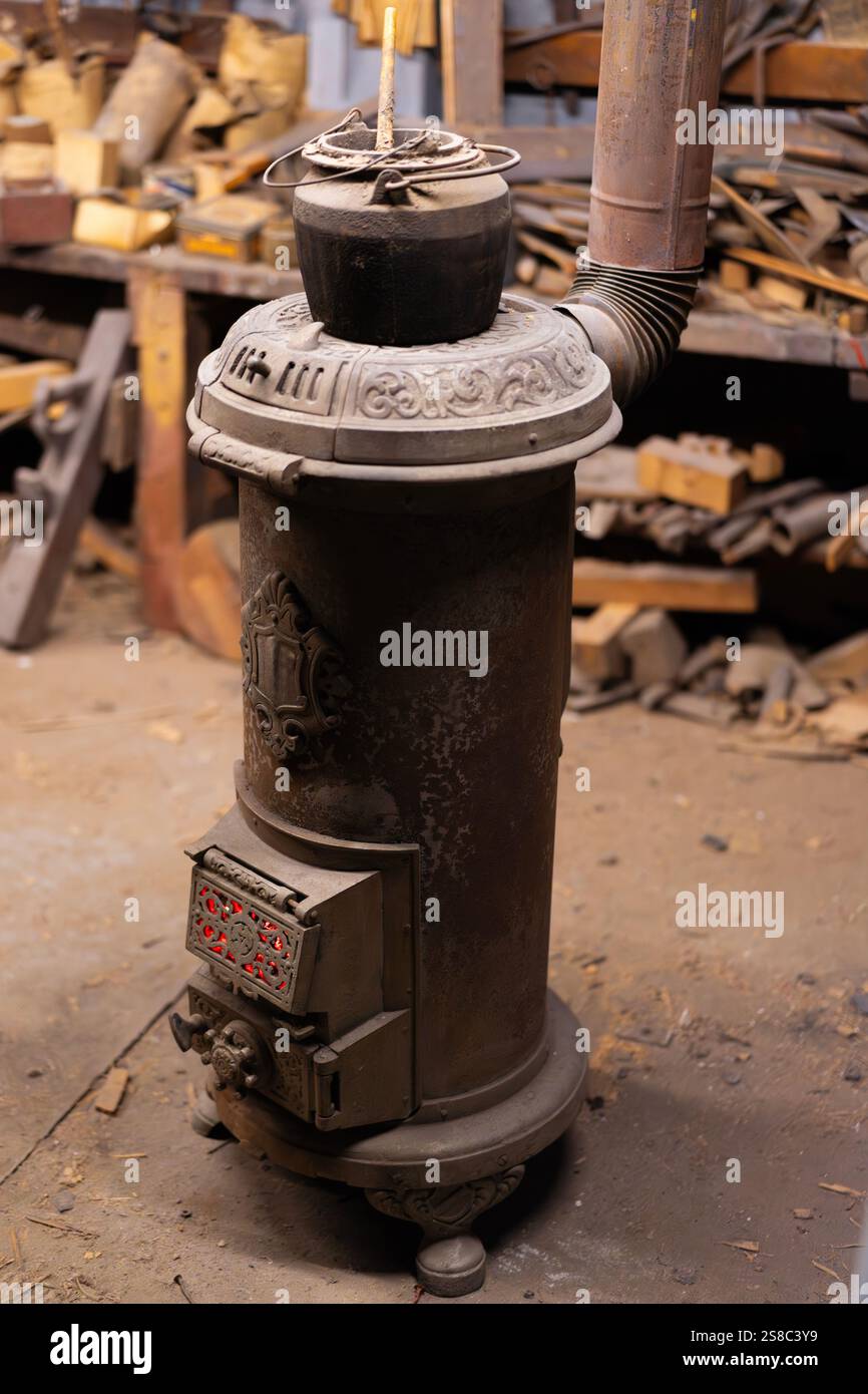 A detailed image of an antique cast iron stove with ornate design in a ...