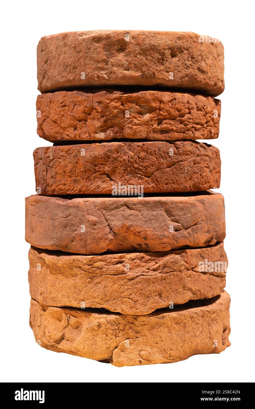 Pile of ancient weathered millstones arranged in a stack isolated on a ...