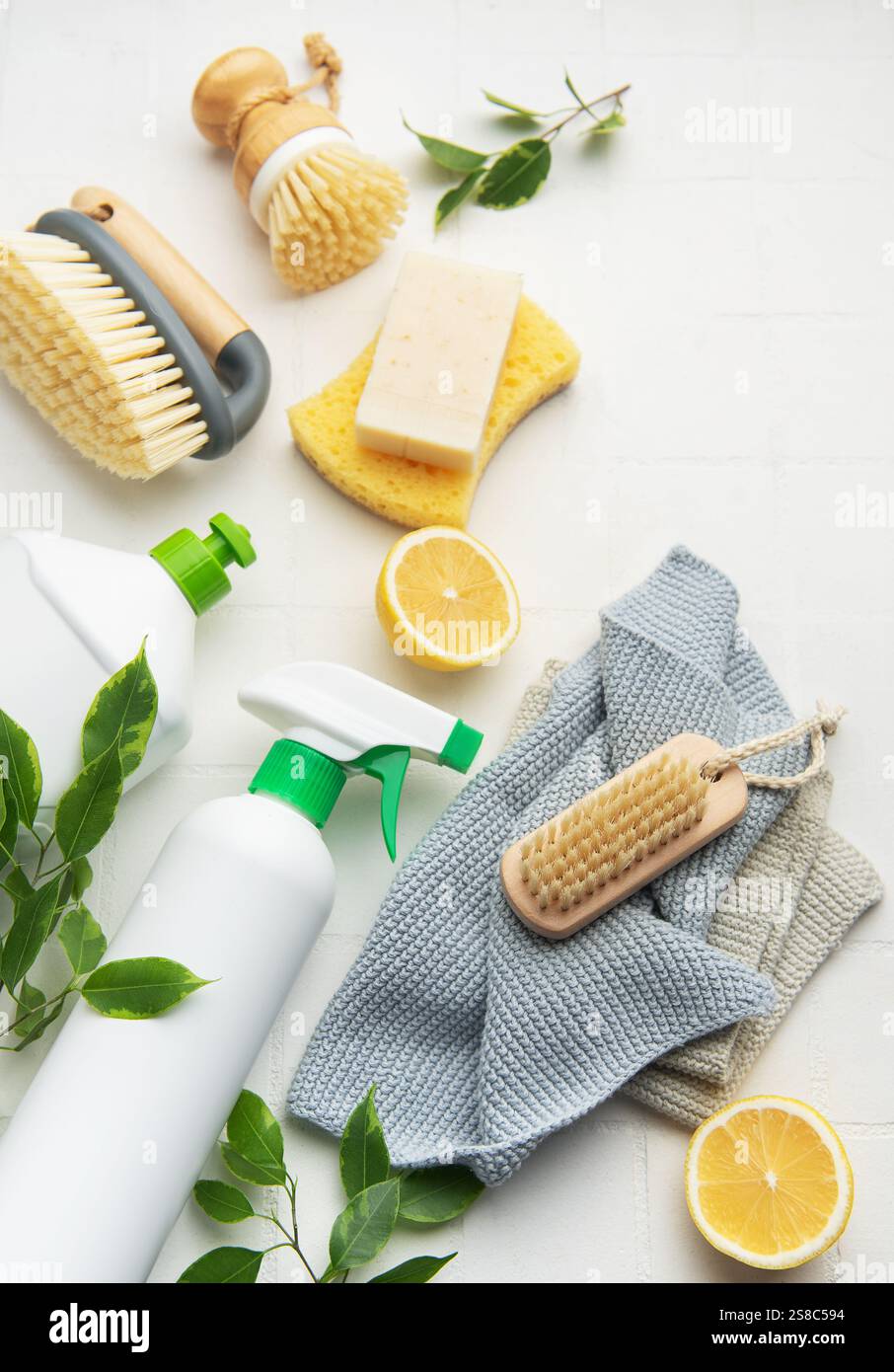 Natural cleaning products, lemon, brushes and cloths arranged on white ...
