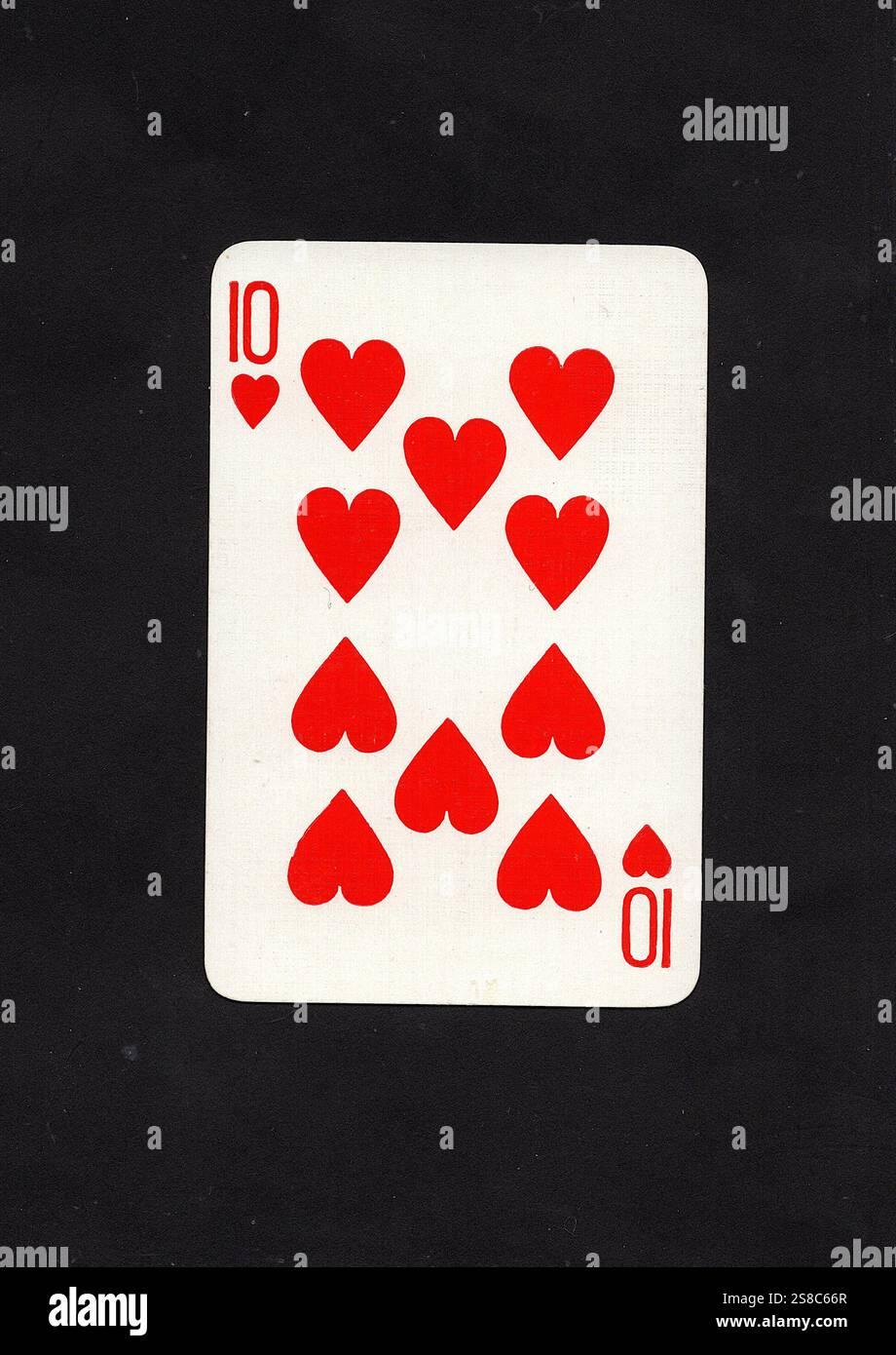 A vintage ten of hearts playing card isolated on a black background ...