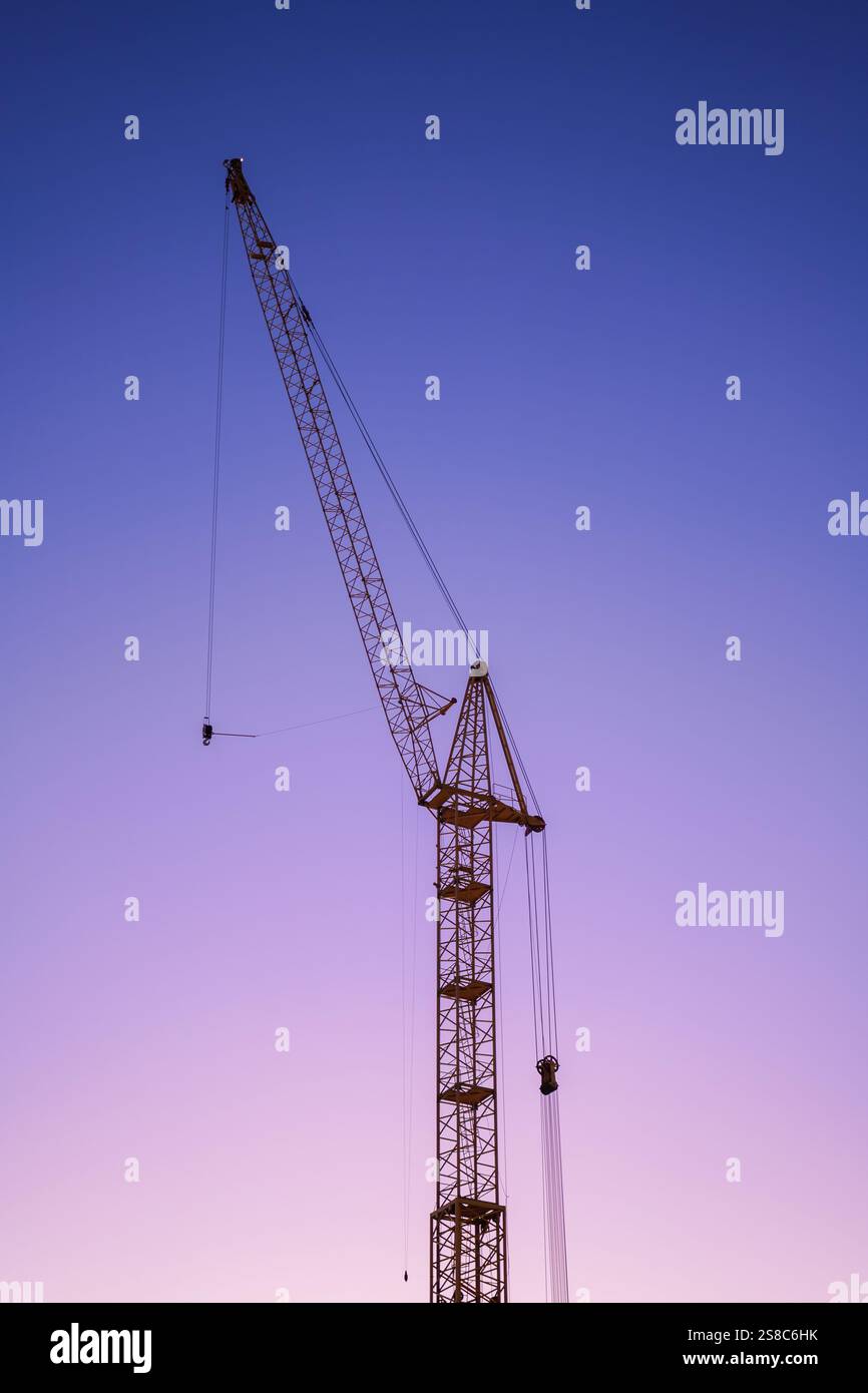 Silhouette of a construction crane against the background of a ...