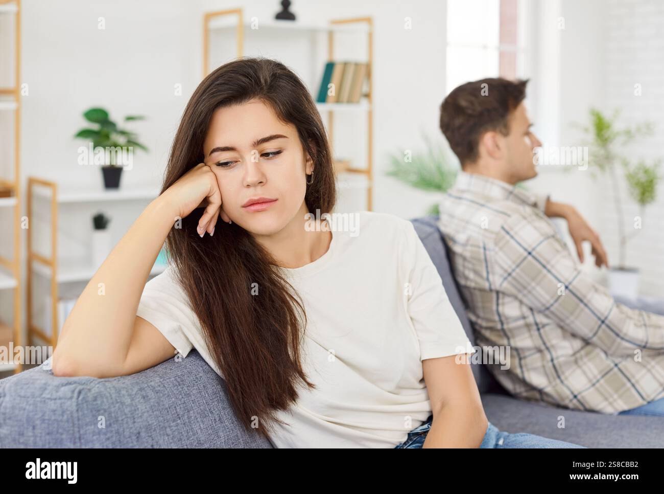 Upset young family couple sitting separately and ignoring each other after quarrel at home Stock ...
