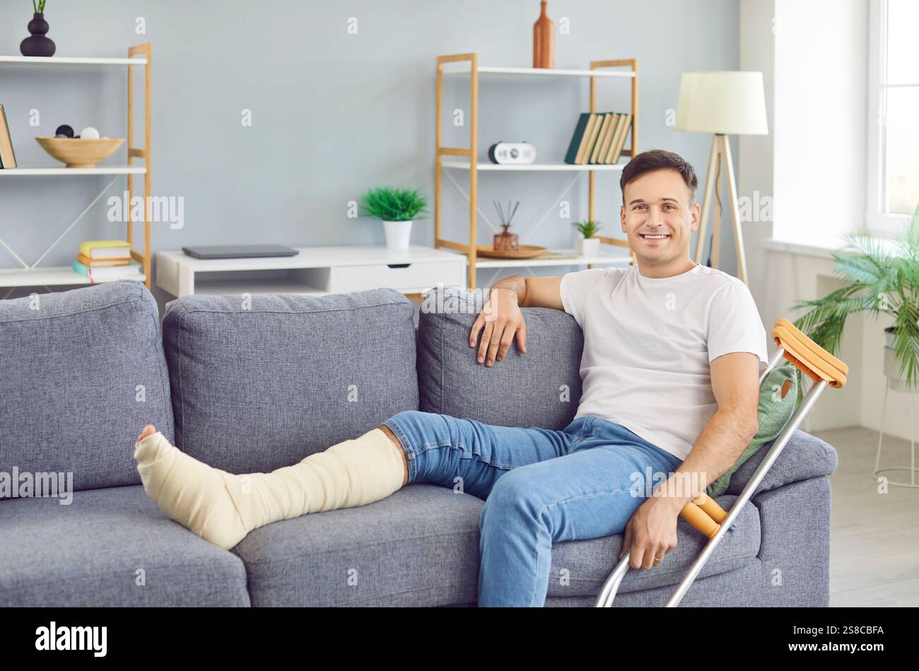 Happy Man With Broken Bandaged Leg Resting At Home Stock Photo - Alamy