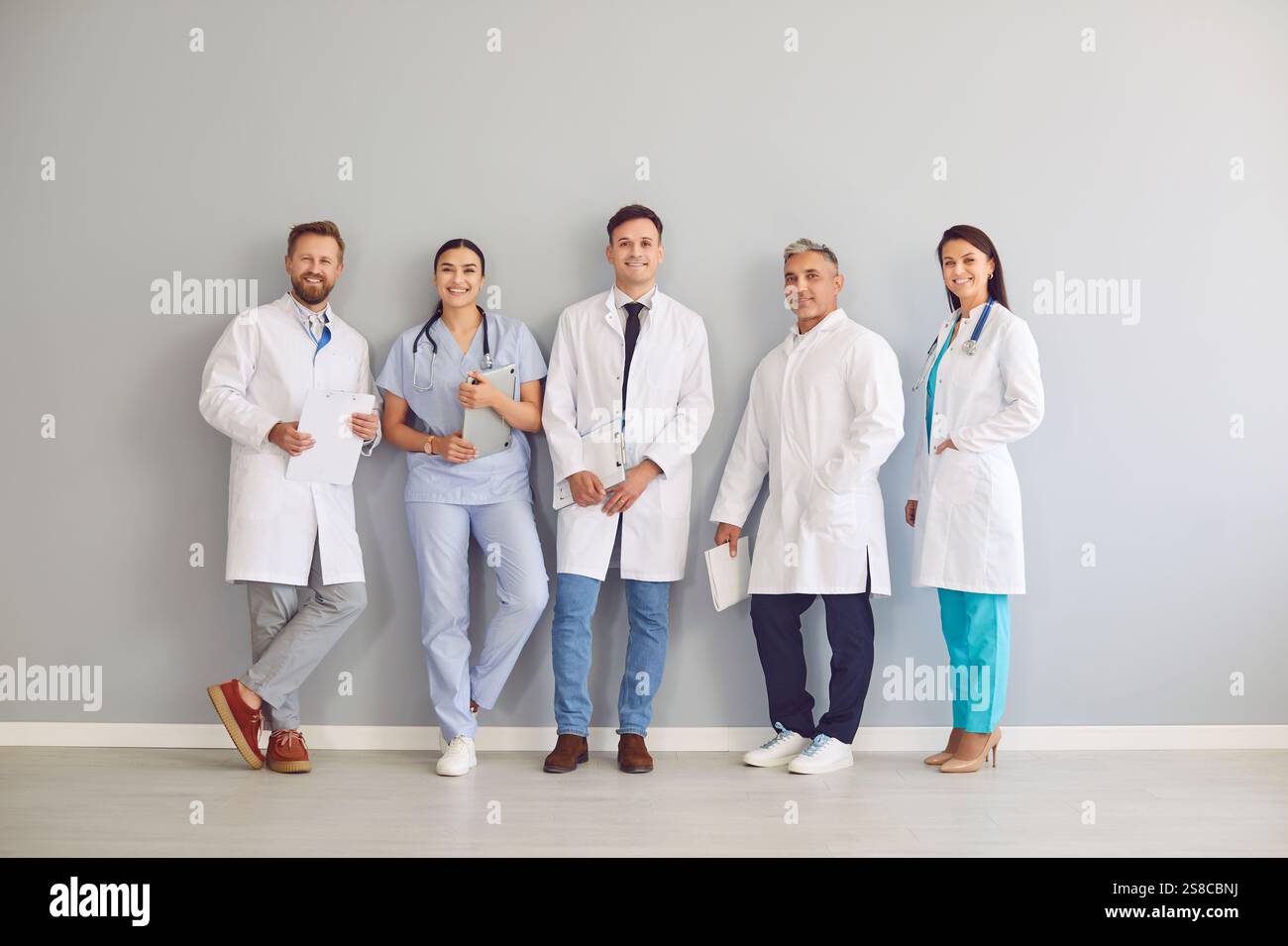 A group of young smiling doctors stand next to a gray wall Stock Photo ...