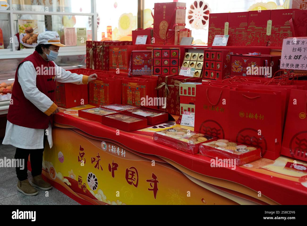 A worker arranges pastries for goodluck ahead of Chinese Lunar New Year ...