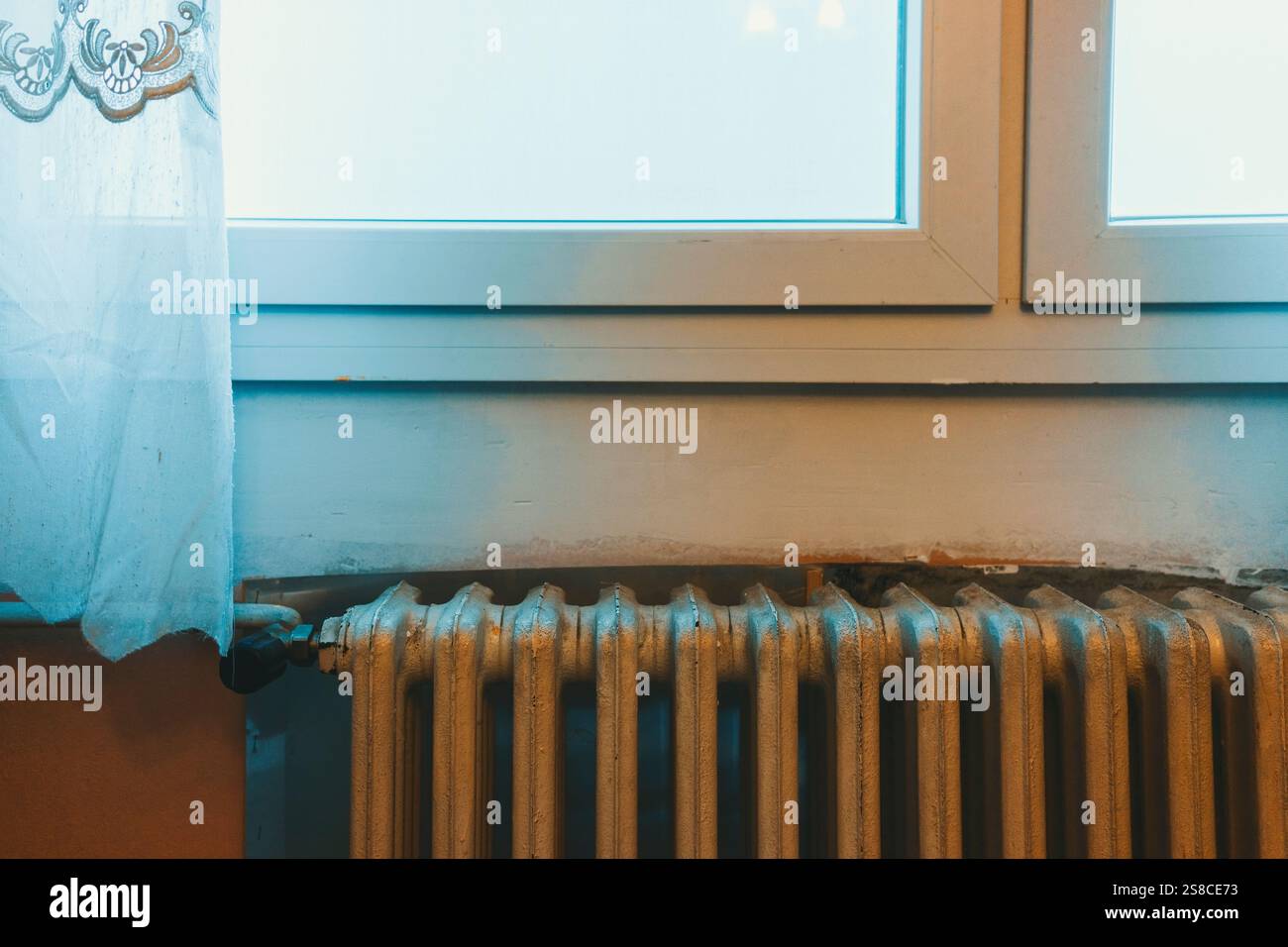Old iron radiator under the window, focus on the ribs Stock Photo - Alamy