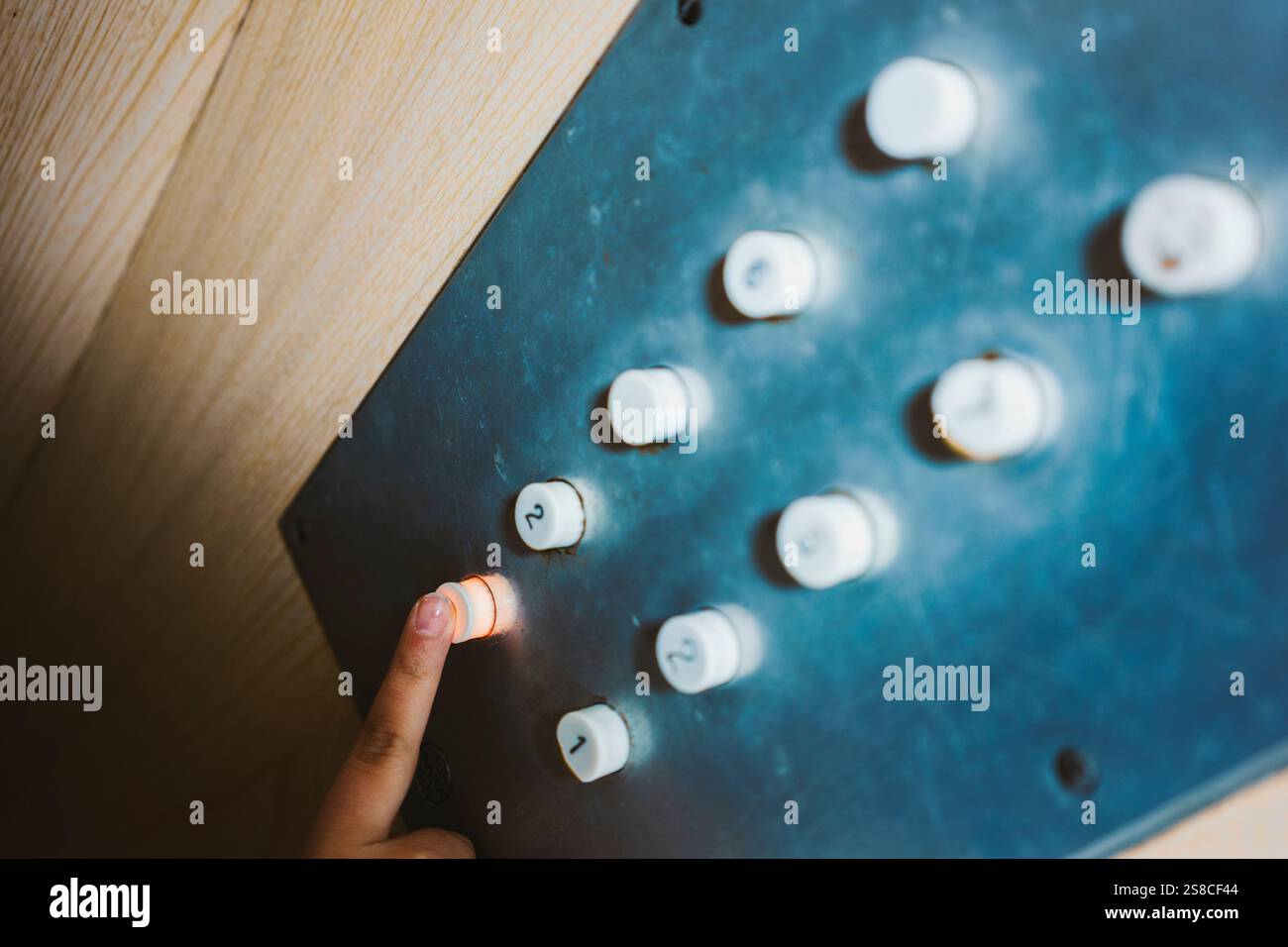 A small child's female hand presses the button in the elevator to go to ...