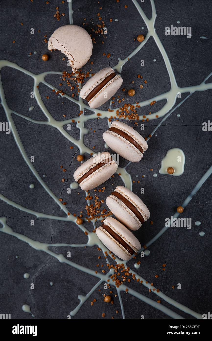 Beige macarons with chocolate filling, sprinkled with caramel crumbs ...