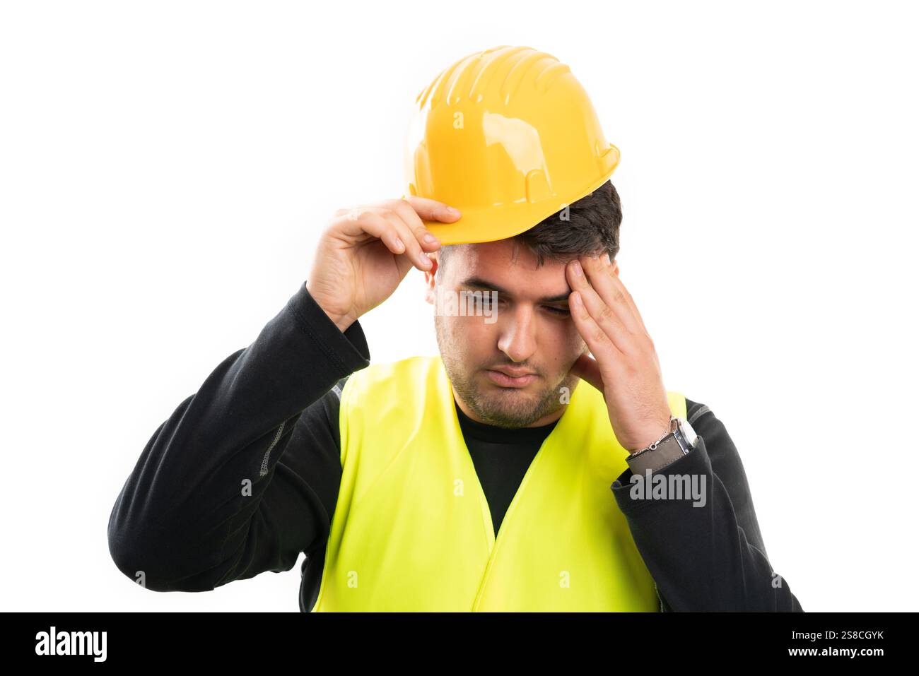 Close-up of male construction worker in work attire touching temple ...