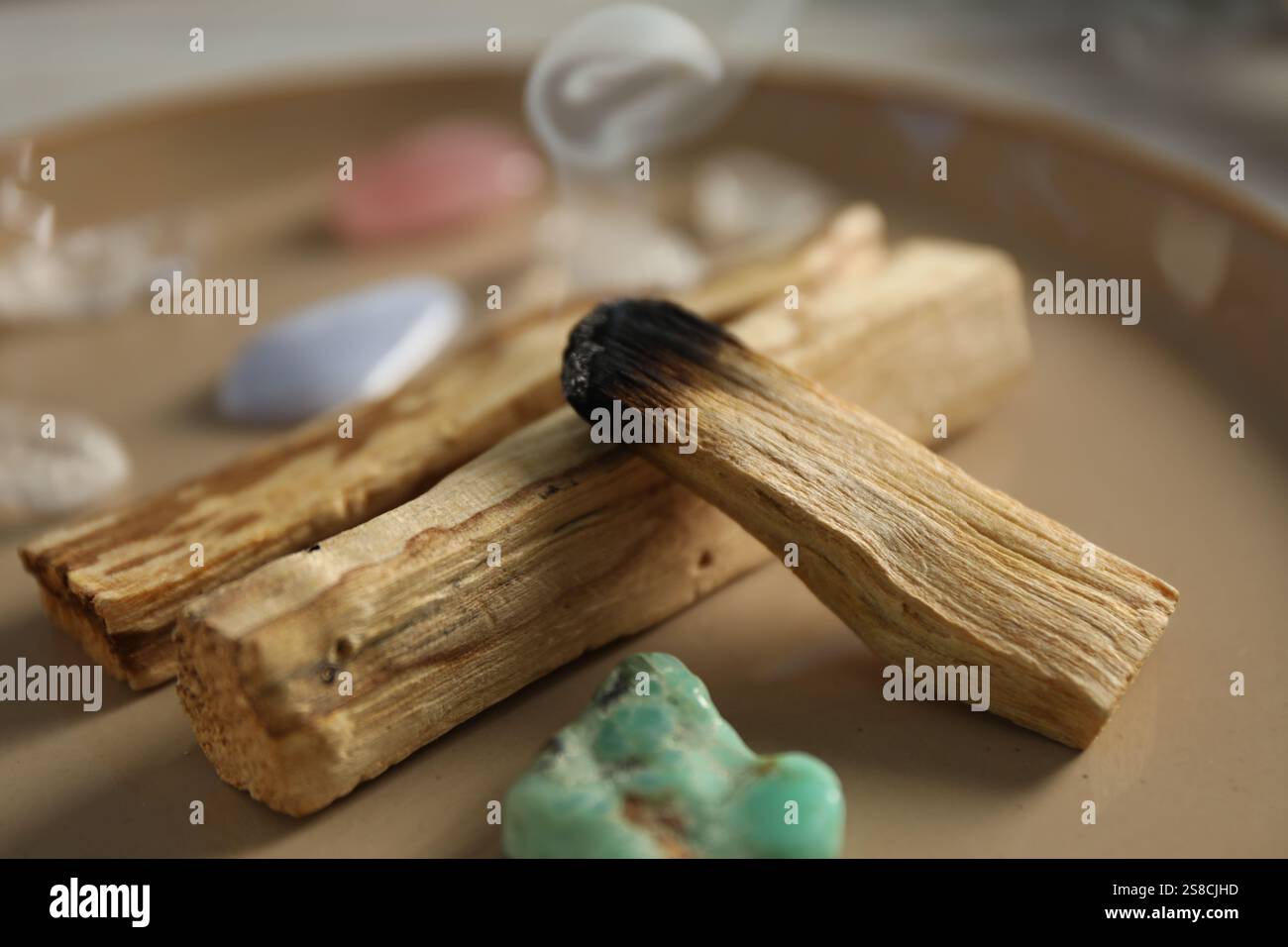 Smoldering palo santo stick and gemstones on plate, closeup Stock Photo ...
